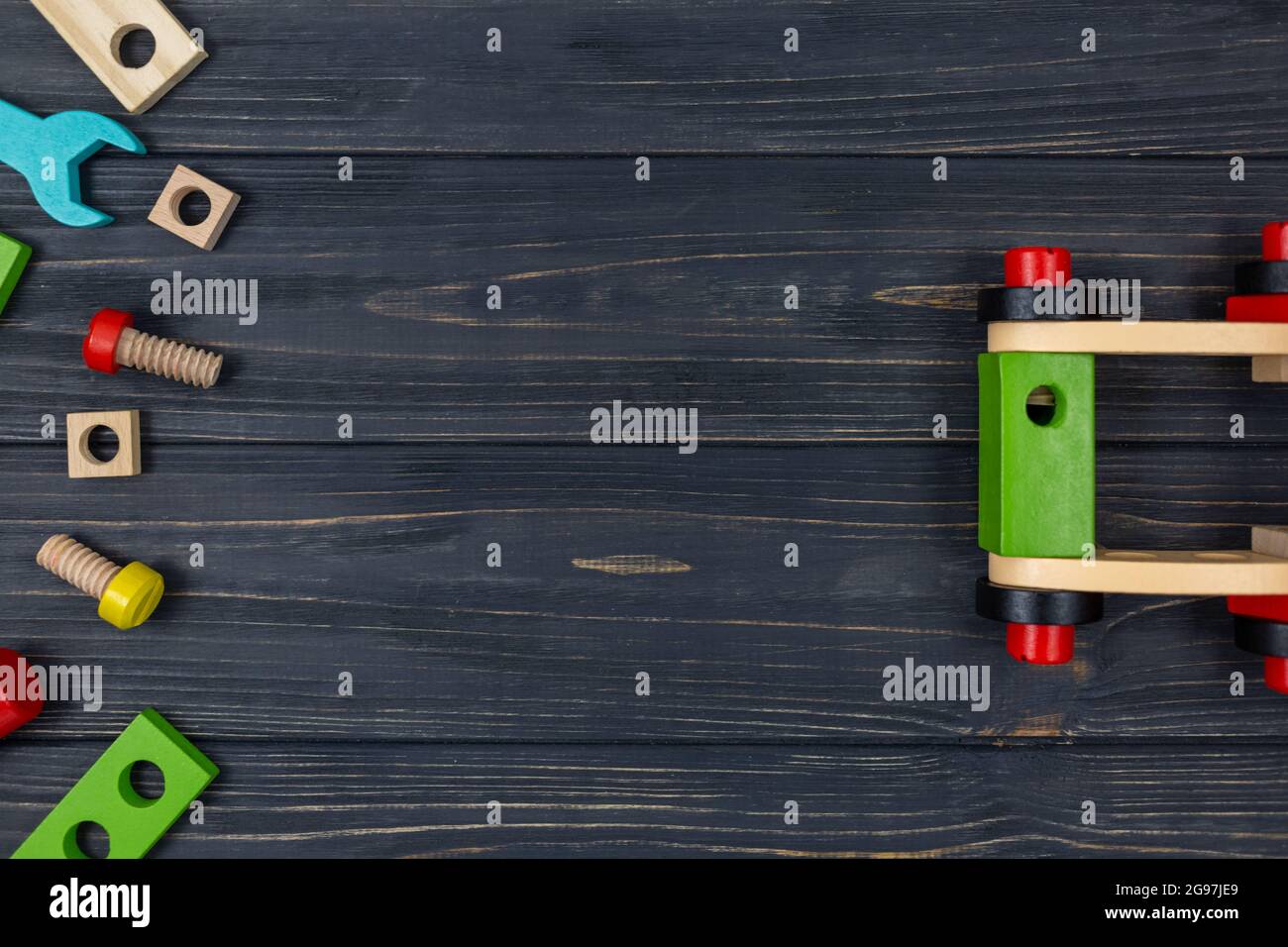 A colorful wooden building kit for children on wood. Set of tools on ...