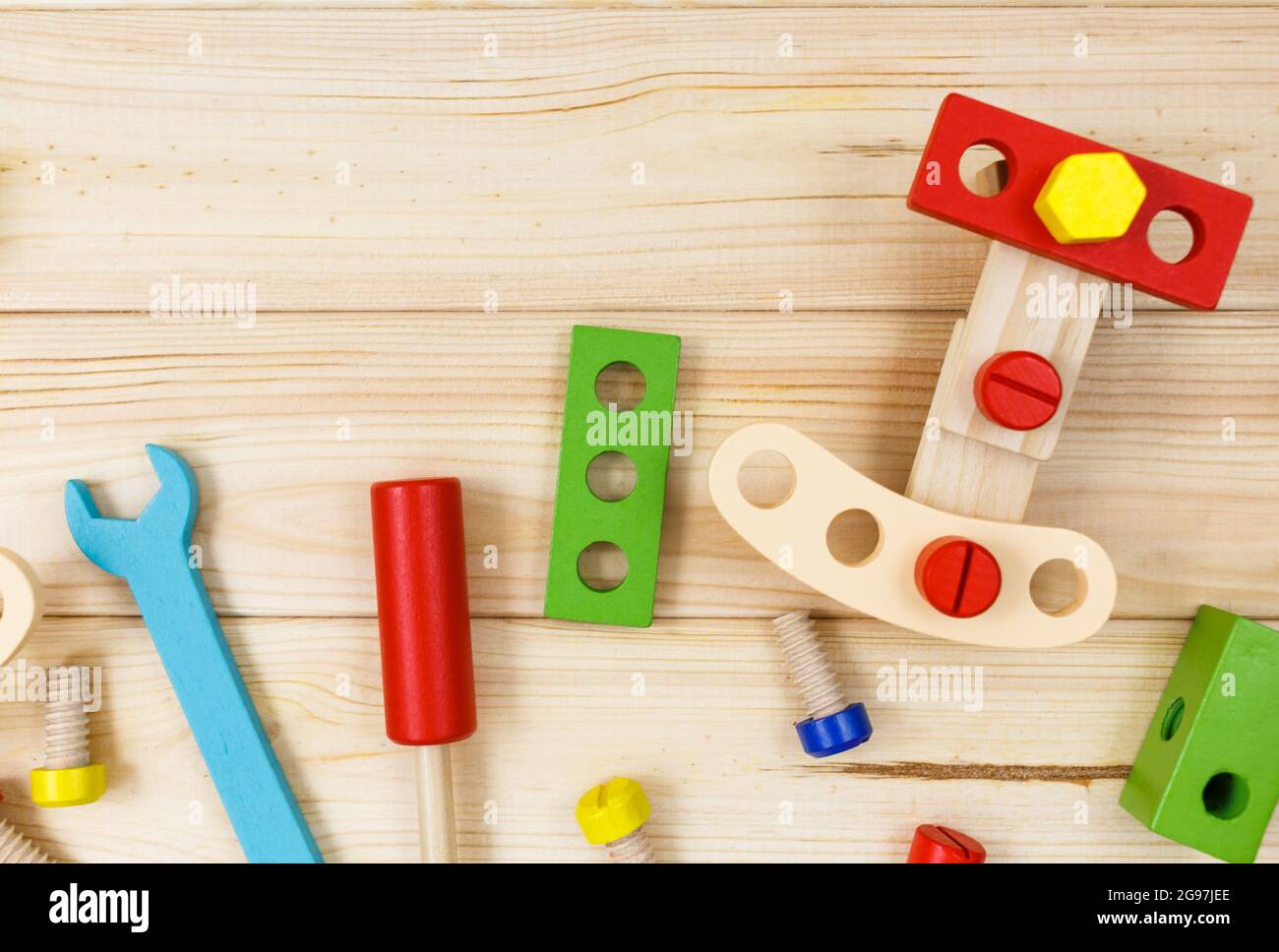 A colorful wooden building kit for children on wood. Set of tools on ...