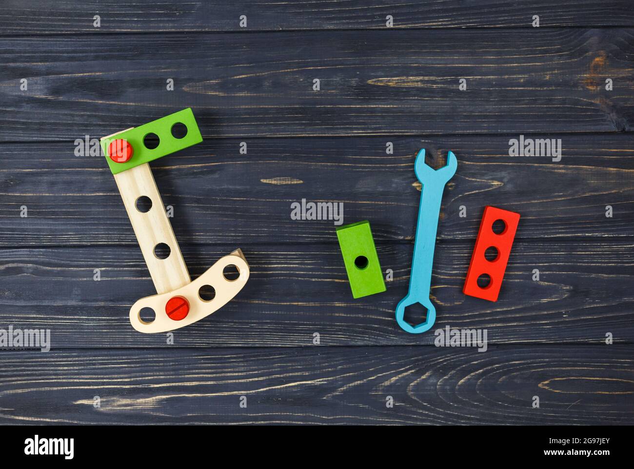 A colorful wooden building kit for children on wood. Set of tools on ...