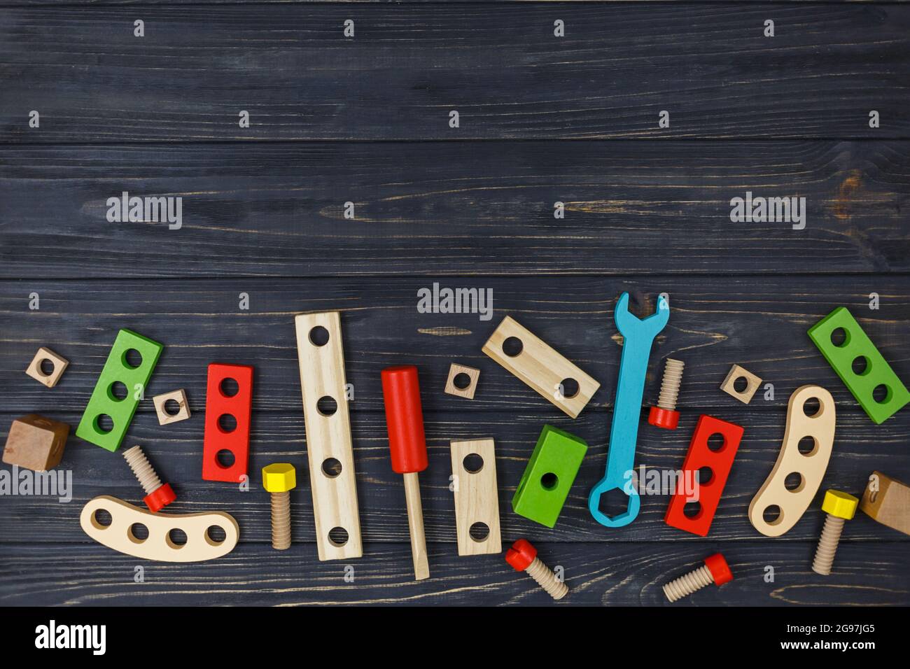 A colorful wooden building kit for children on wood. Set of tools on ...