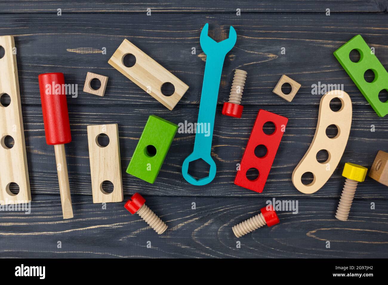 A colorful wooden building kit for children on wood. Set of tools on ...