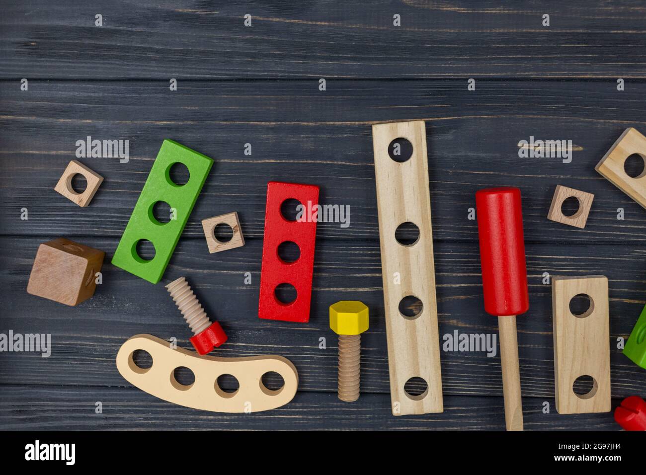 A colorful wooden building kit for children on wood. Set of tools on ...