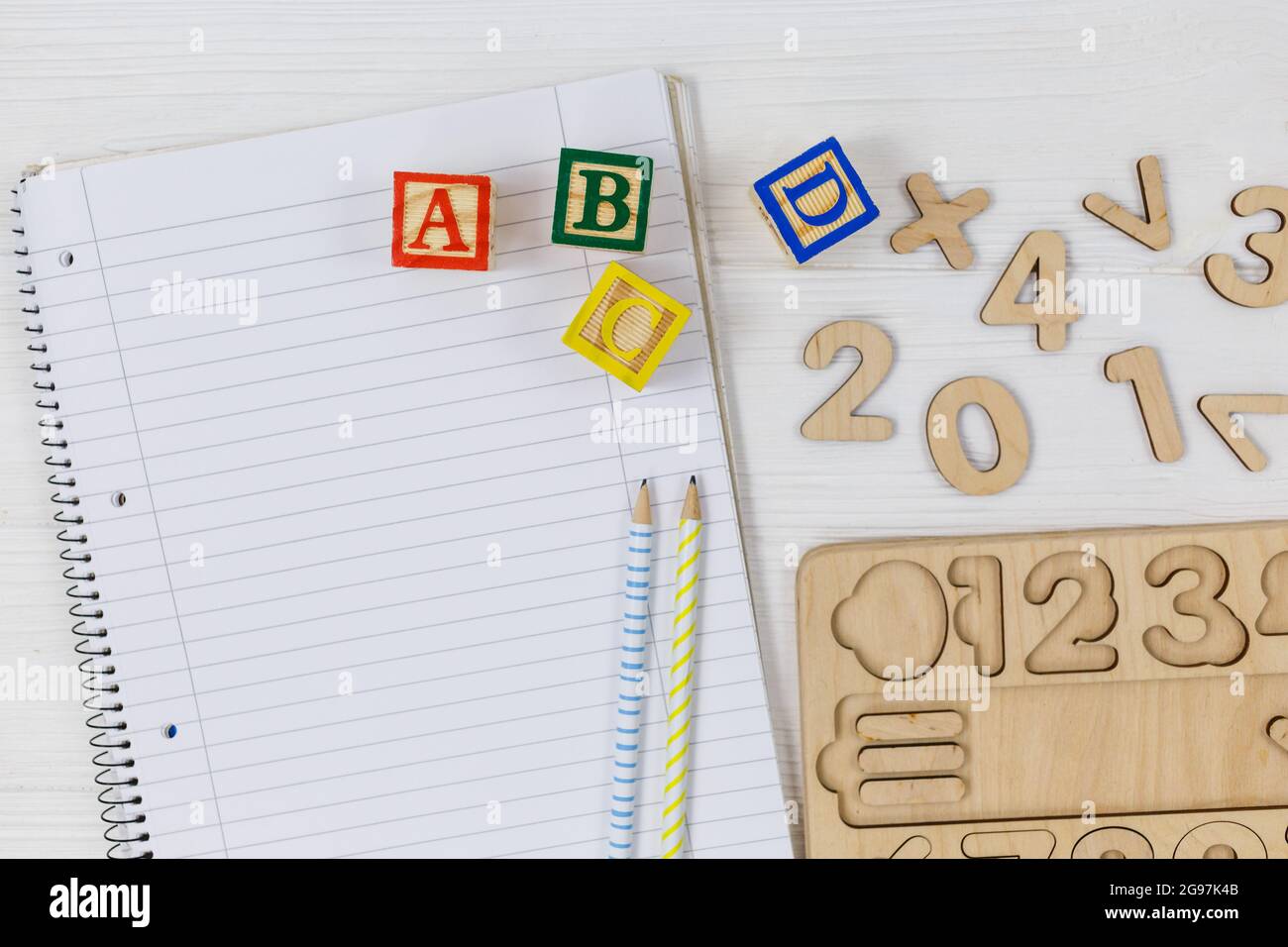 Wooden blocks with ABC letters, open notepad, numbers on wooden table ...
