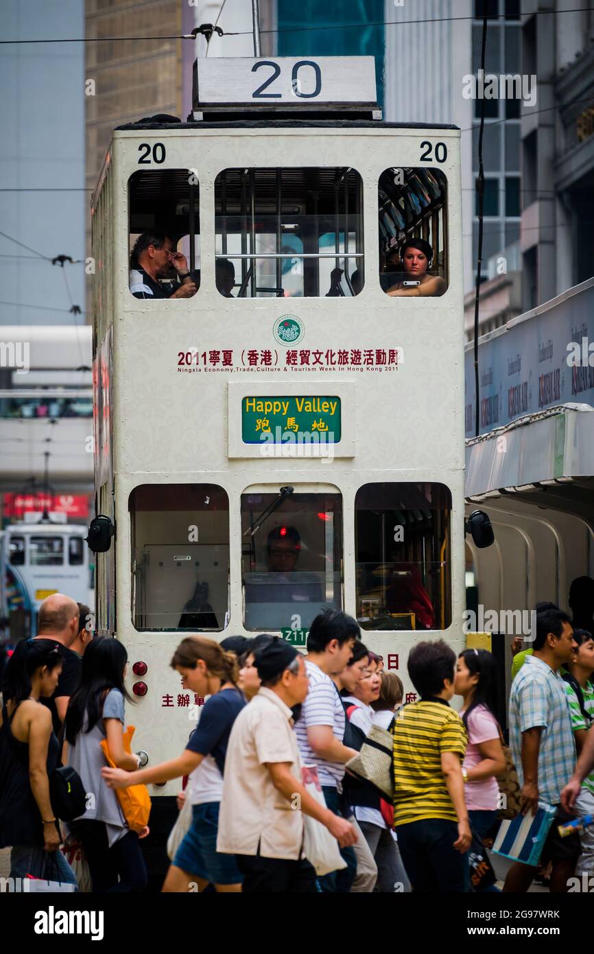 Pedestrians cross Des Voeux Road, Central, Hong Kong Island, in front ...
