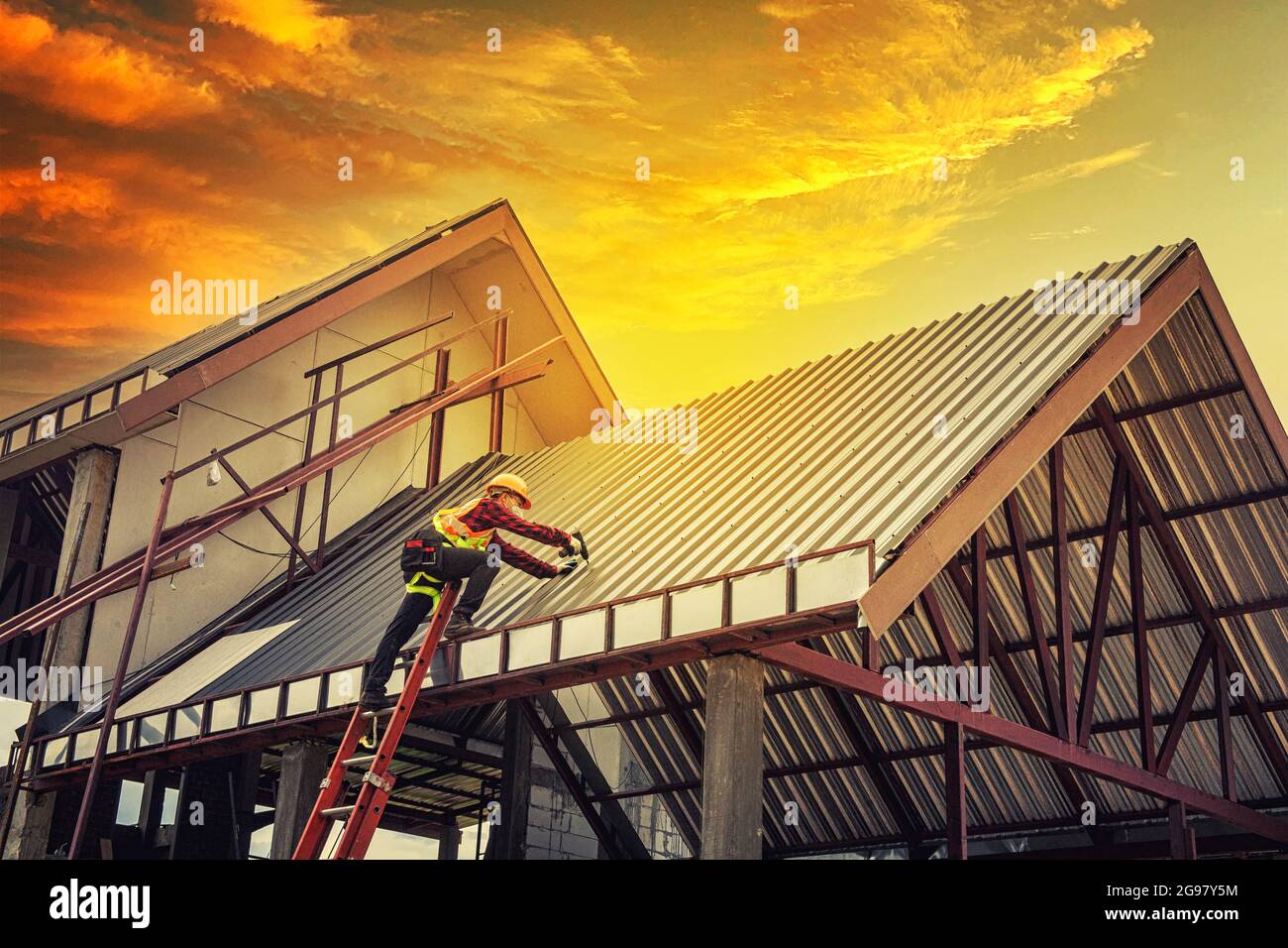 Worker man building tradesman on the roof of a house with safety helmet ...
