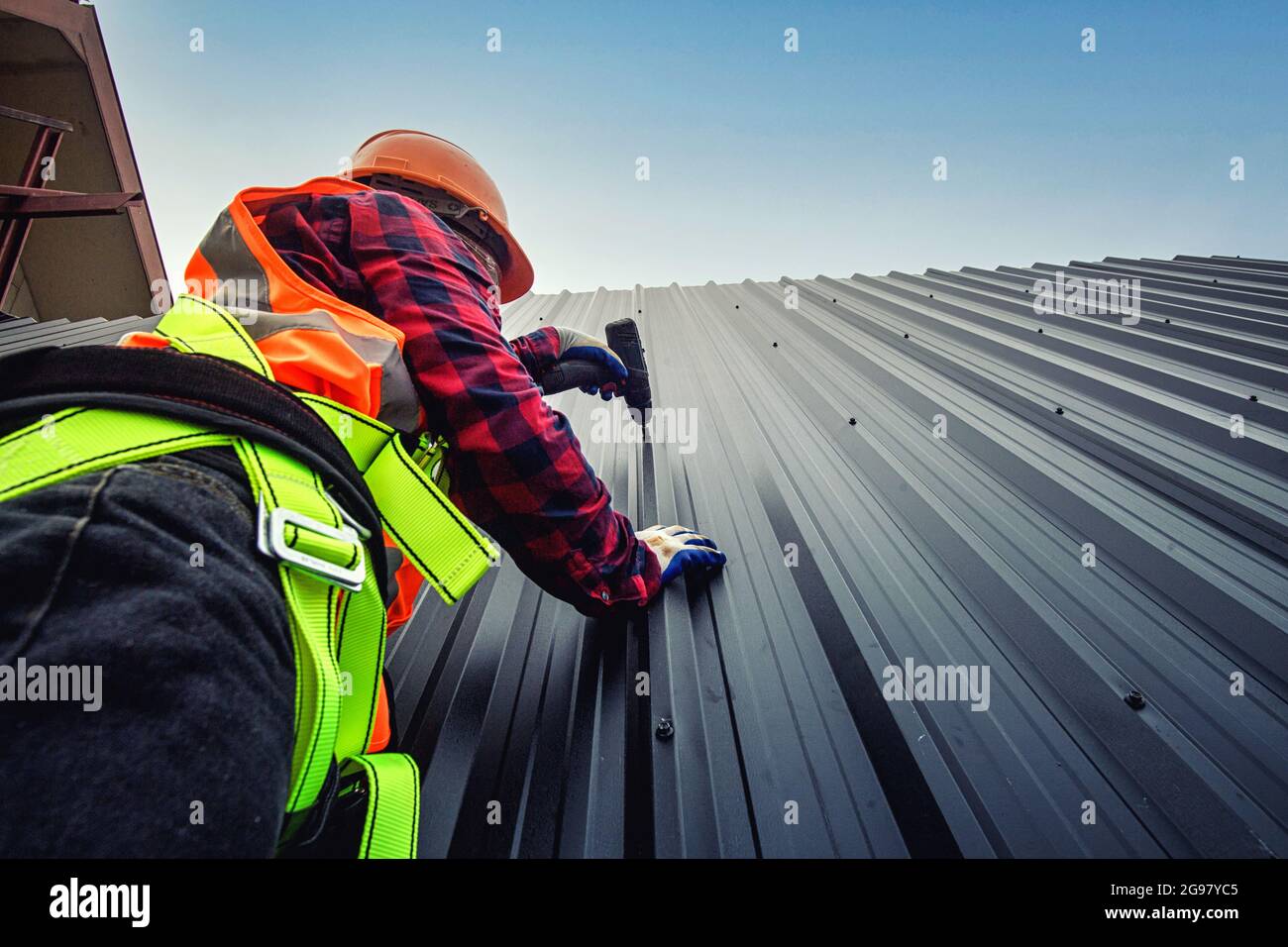 Worker man building tradesman on the roof of a house with safety helmet ...