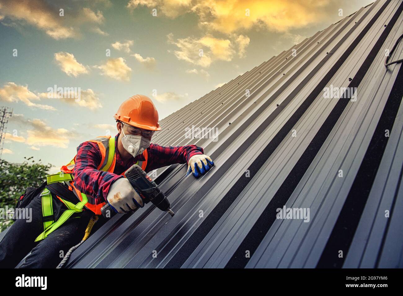 Worker man building tradesman on the roof of a house with safety helmet ...