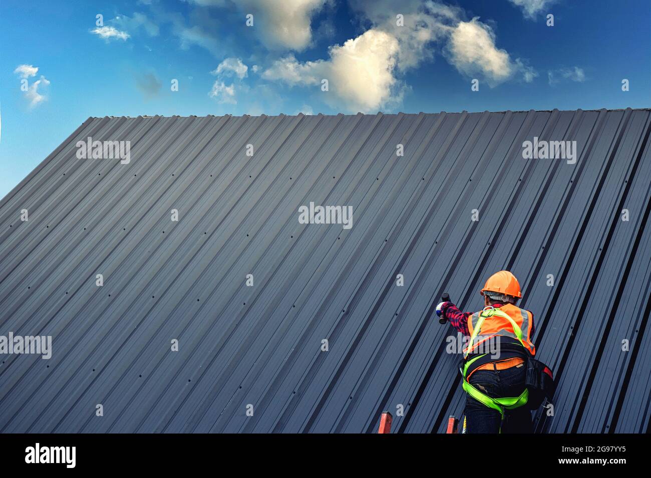 Worker man building tradesman on the roof of a house with safety helmet ...