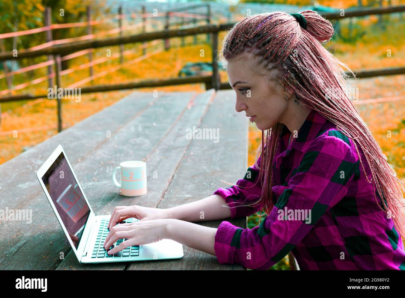 side view of a young modern woman working on the computer in the ...