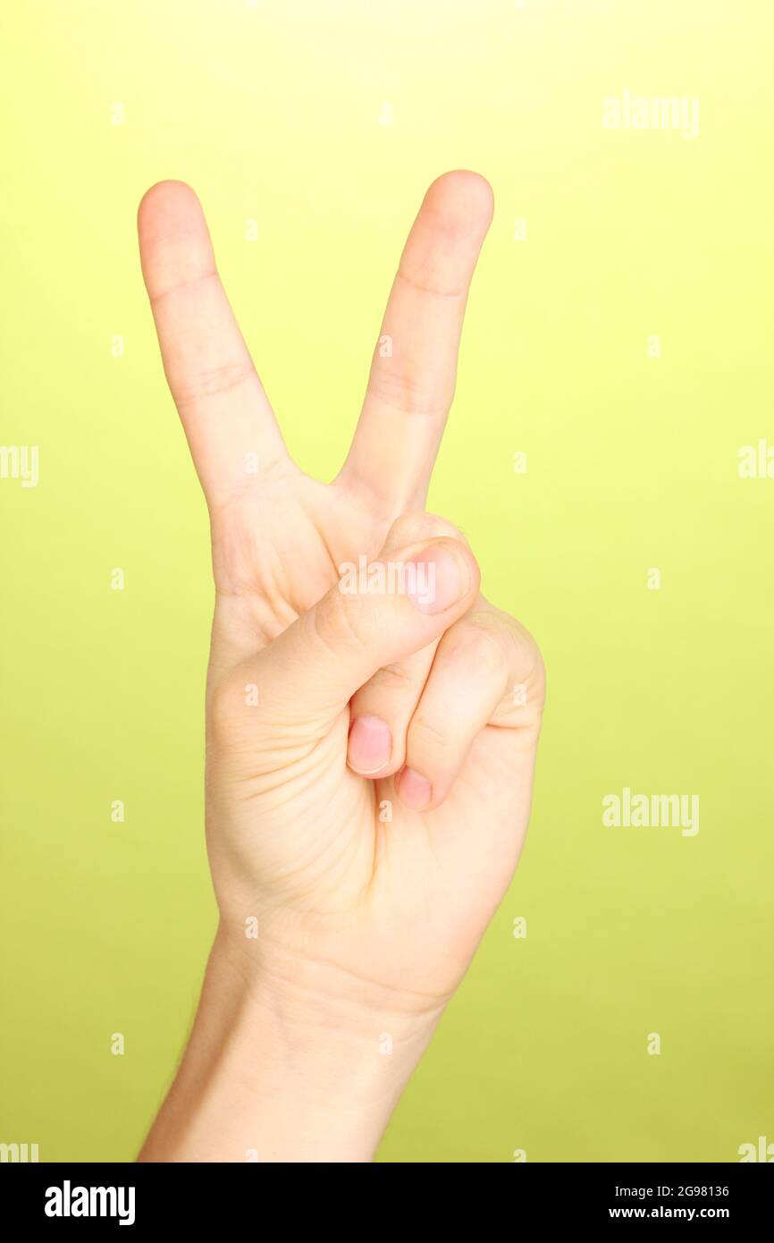 Hand making sign on green background Stock Photo - Alamy