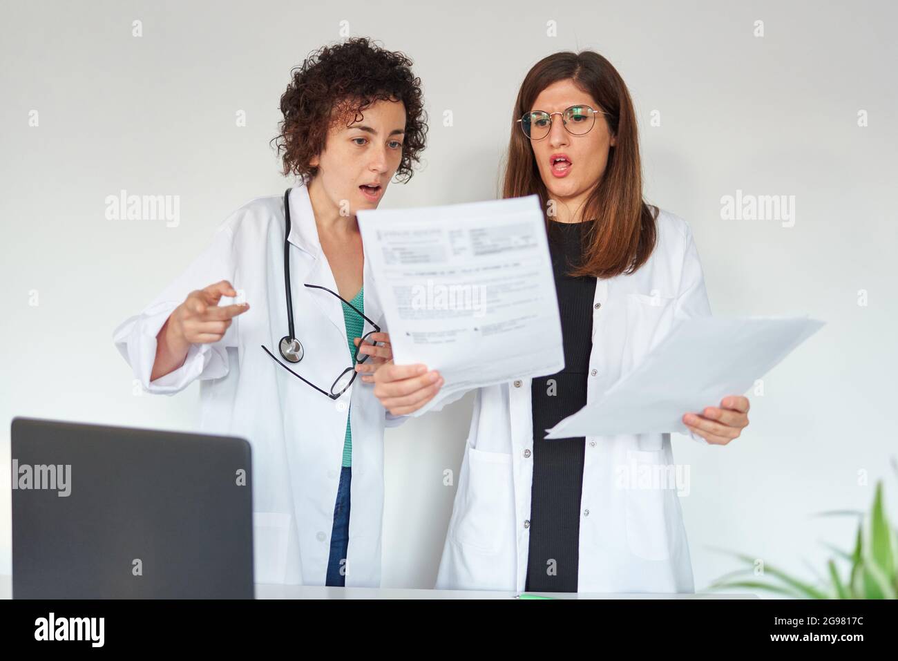 two surprised female doctors look at documents Stock Photo - Alamy