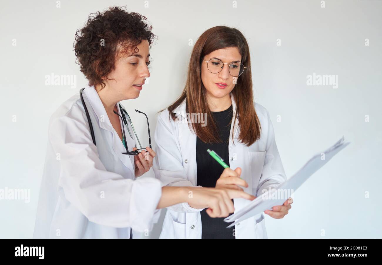 Two female doctors look at documents and discuss a diagnosis Stock ...