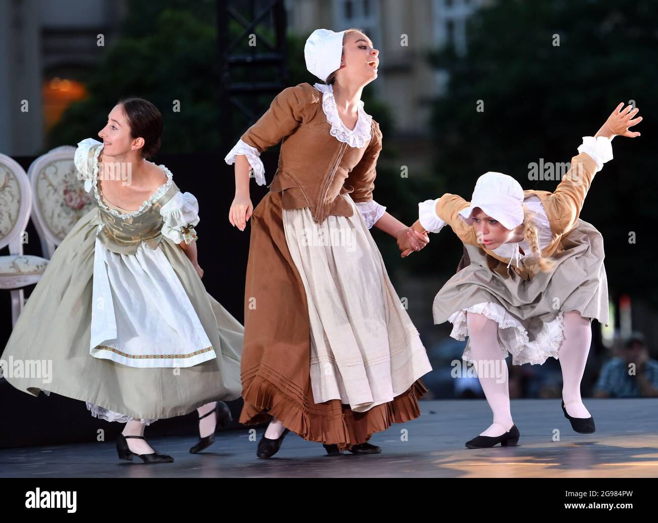 Artists in costumes performing on stage during a show of court dances ...