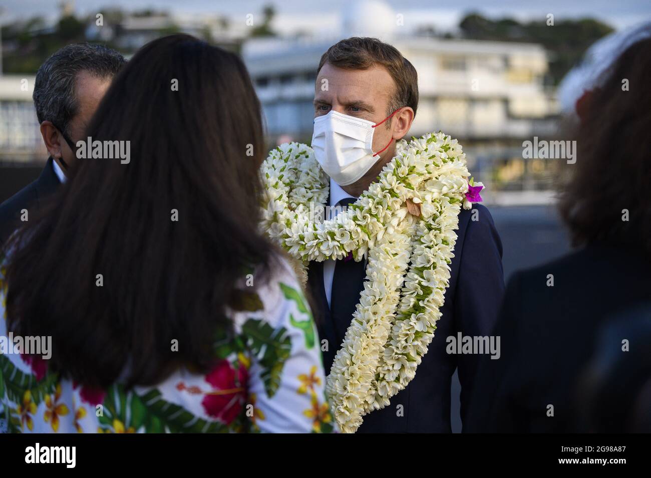 France's President Emmanuel Macron is wrapped in garlands as he is ...