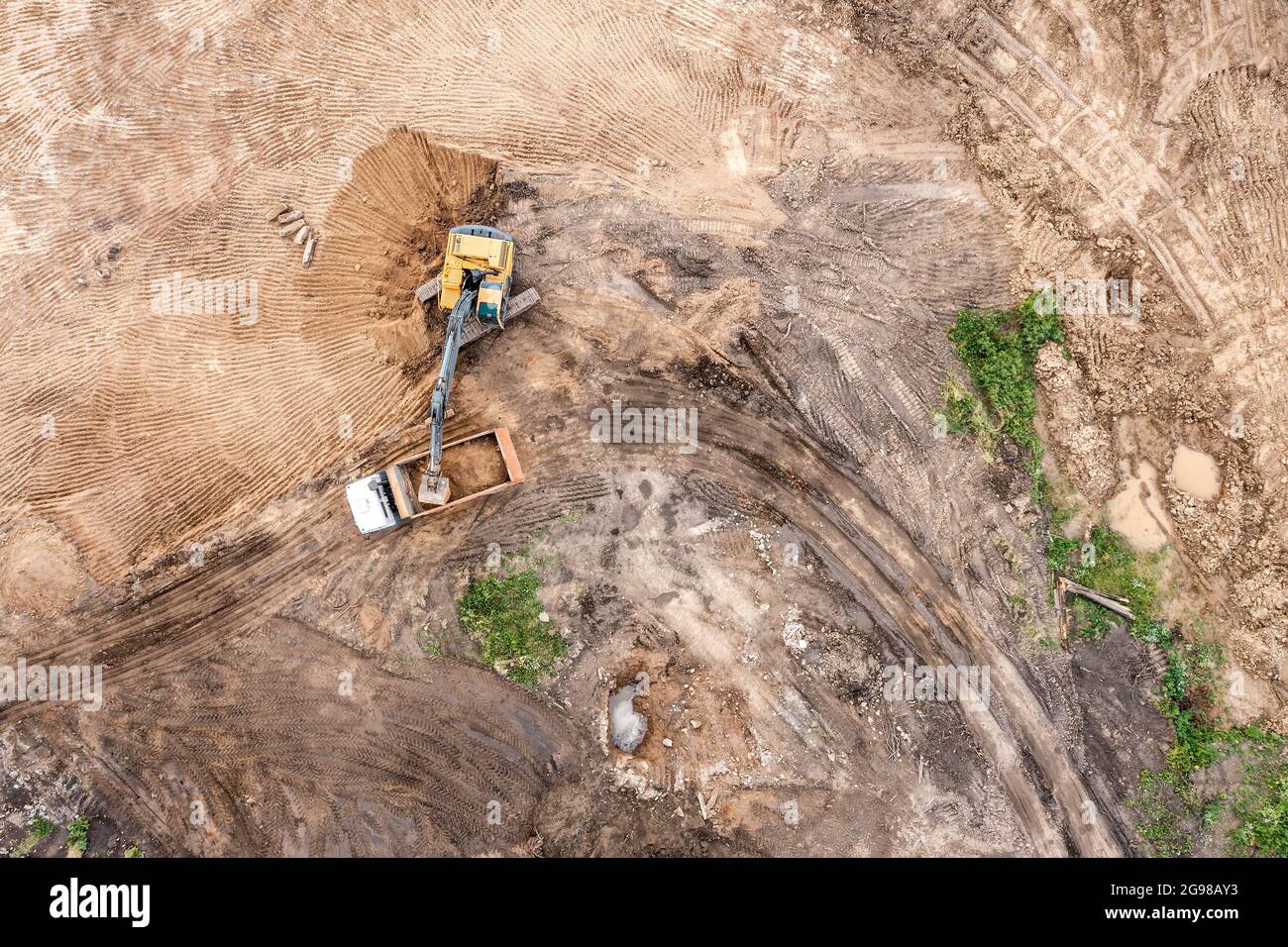 excavator is loading soil into a dump truck. earthworks on construction site. working industrial ...
