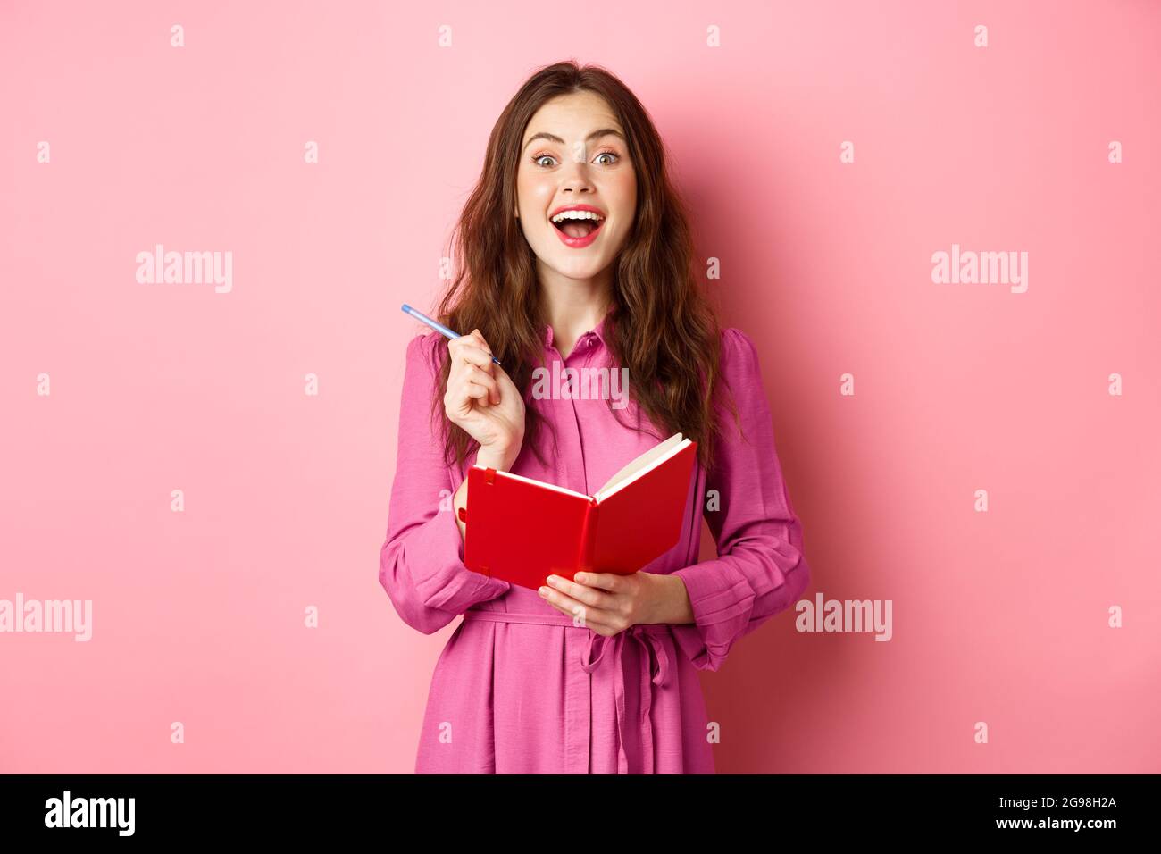 Excited young woman have excellent idea, writing down her ideas in ...
