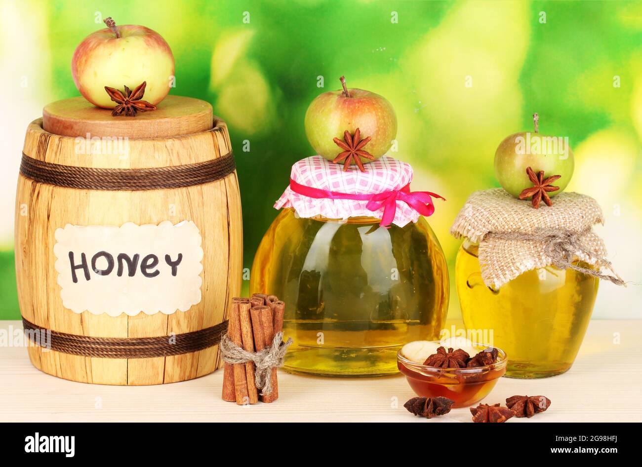 Honey and apples with cinnamon on wooden table on natural background ...
