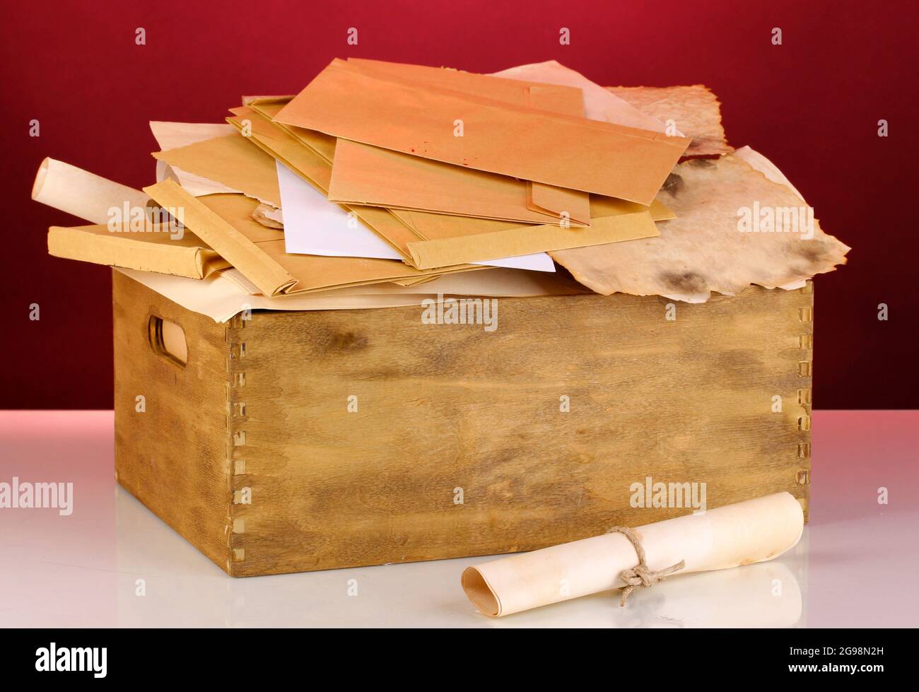 Wooden crate with papers and letters on red background Stock Photo - Alamy