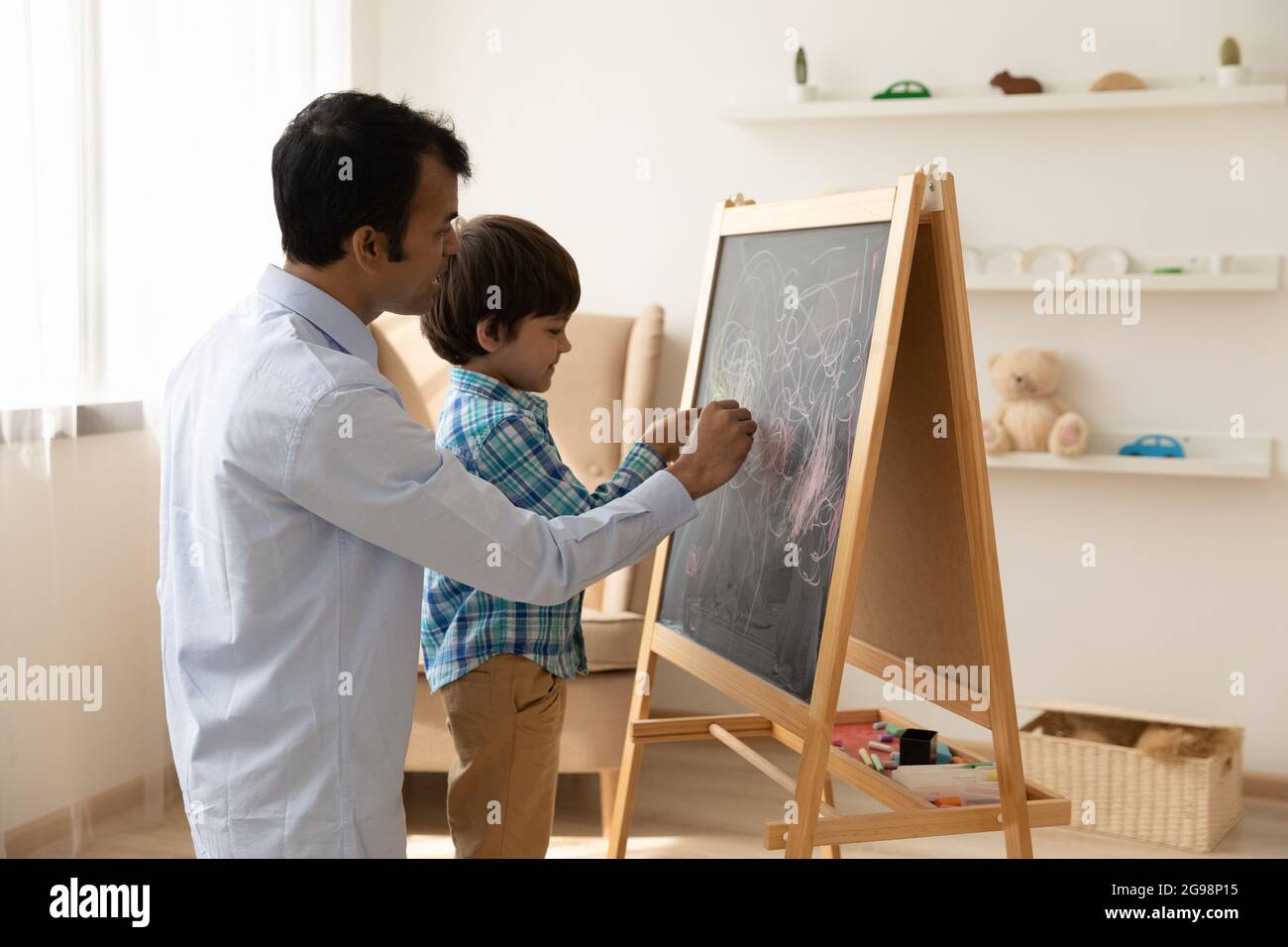 Indian father with little son drawing on chalk board together Stock ...