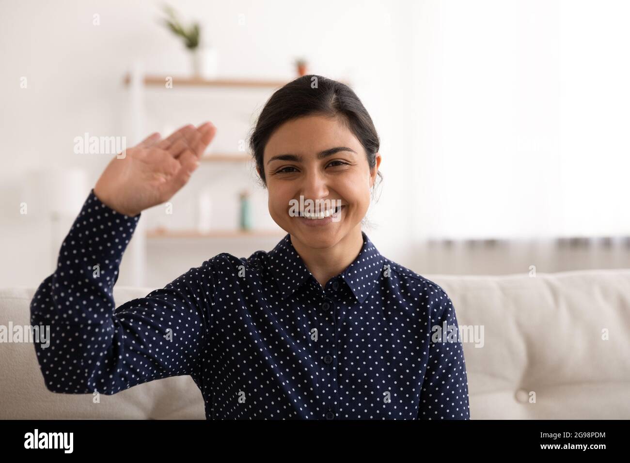 Head shot portrait smiling Indian woman waving hand at camera Stock ...