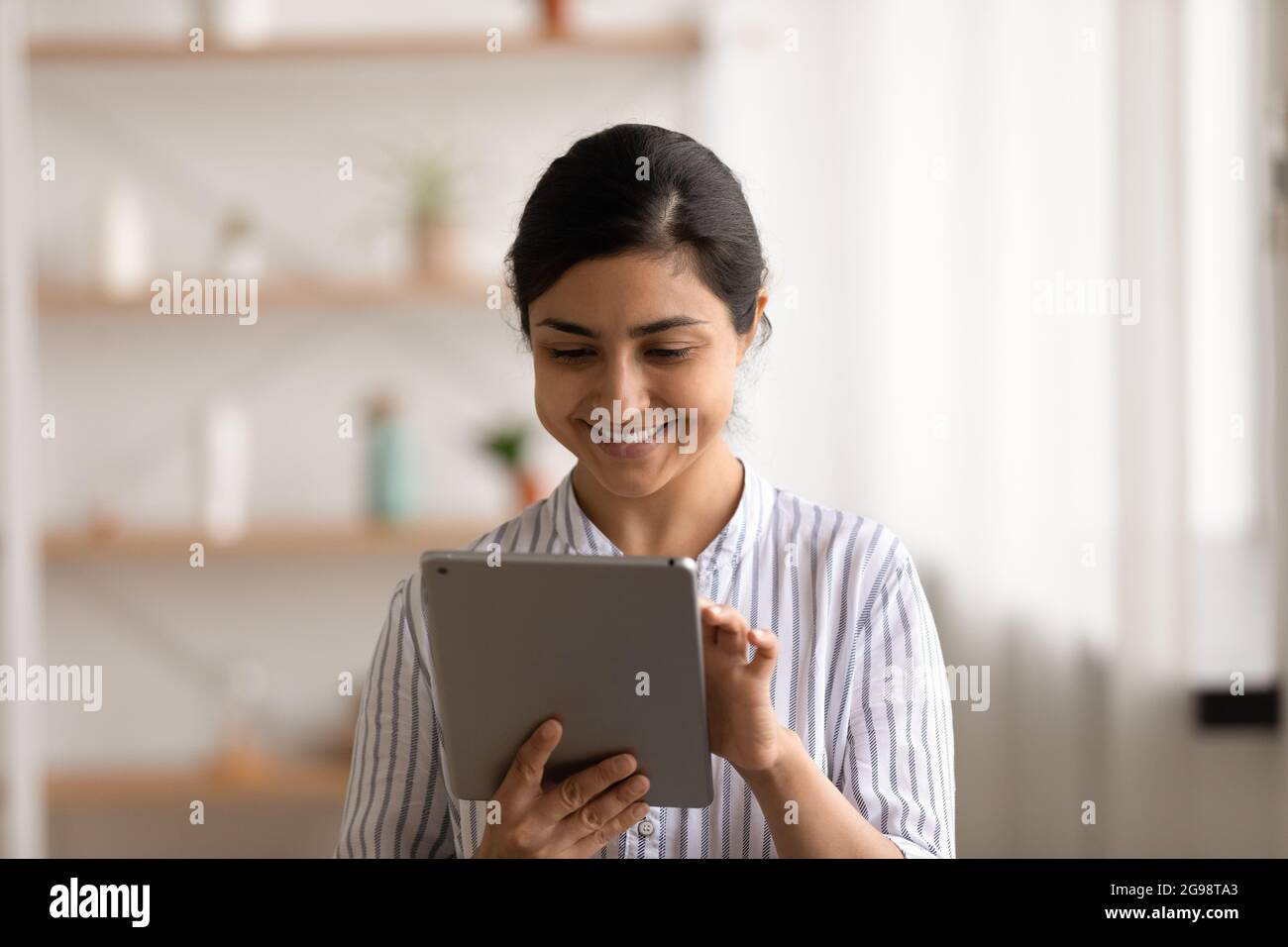 Head shot smiling Indian woman using tablet, having fun Stock Photo - Alamy
