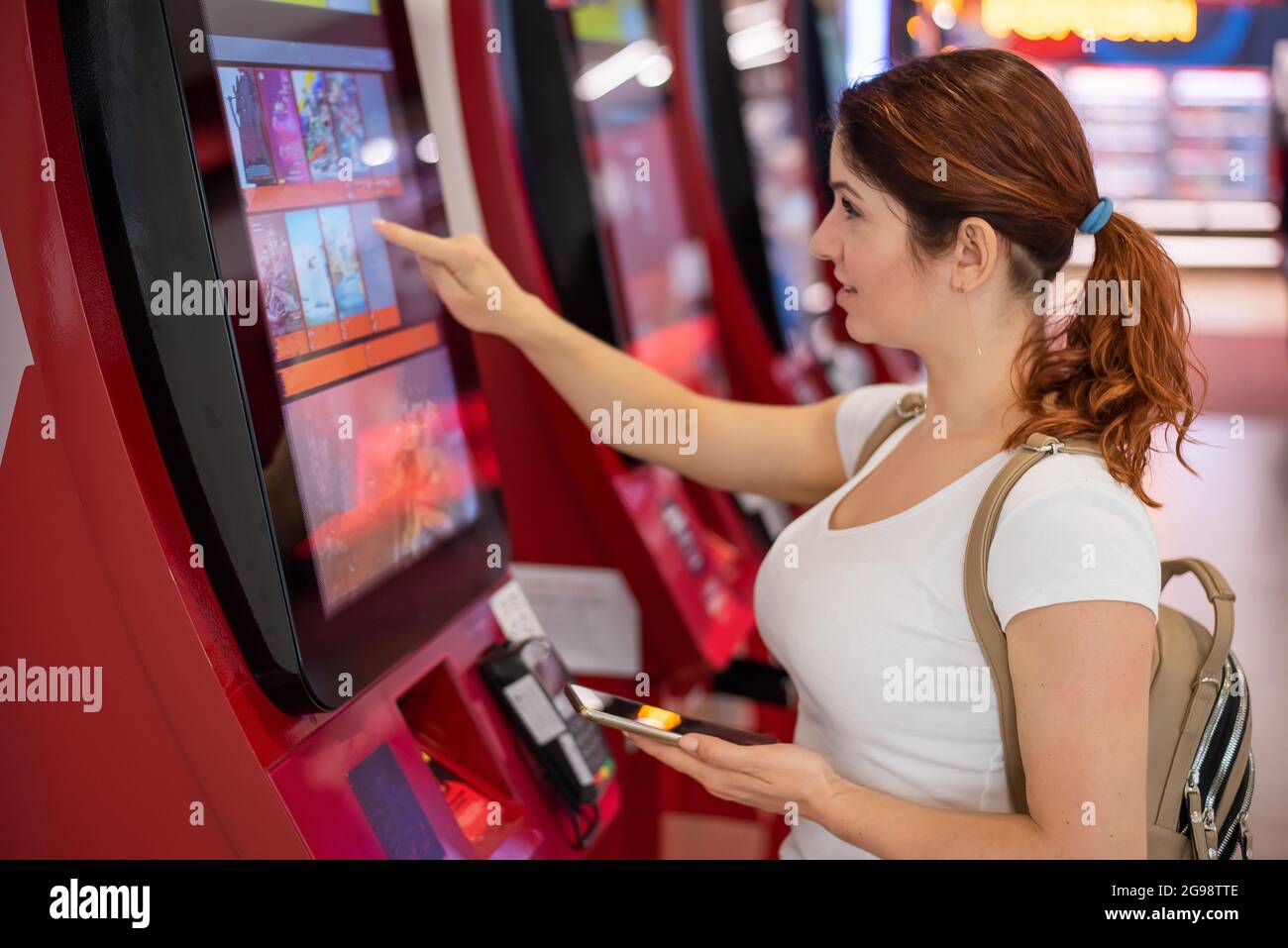 Caucasian woman buying cinema ticket at self-service box office Stock ...
