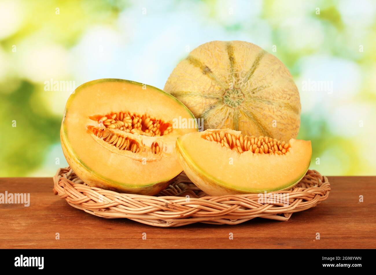 cut melon on wicker mat on green background close-up Stock Photo - Alamy
