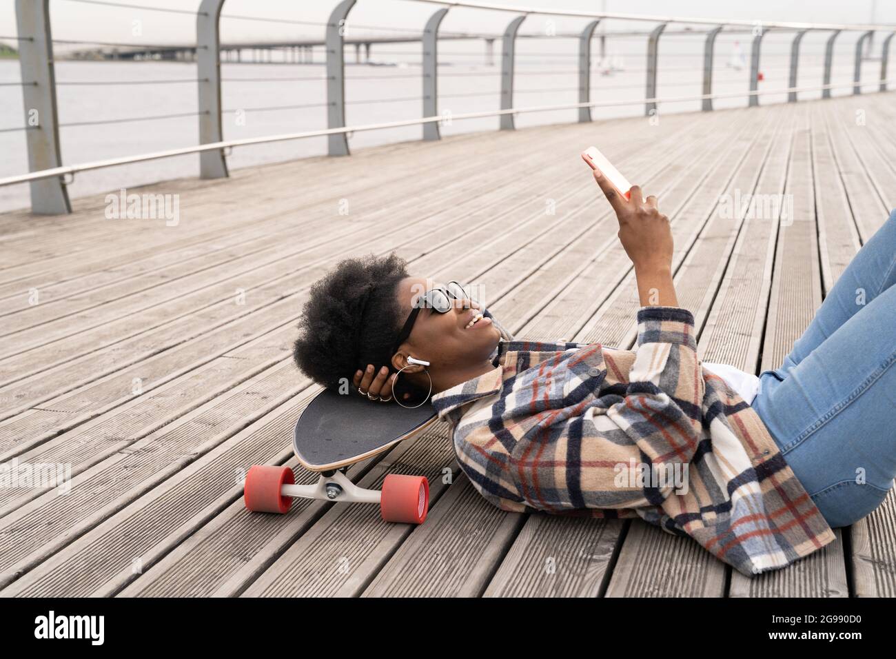 African skater girl chat in smartphone, black female messaging lying on ...