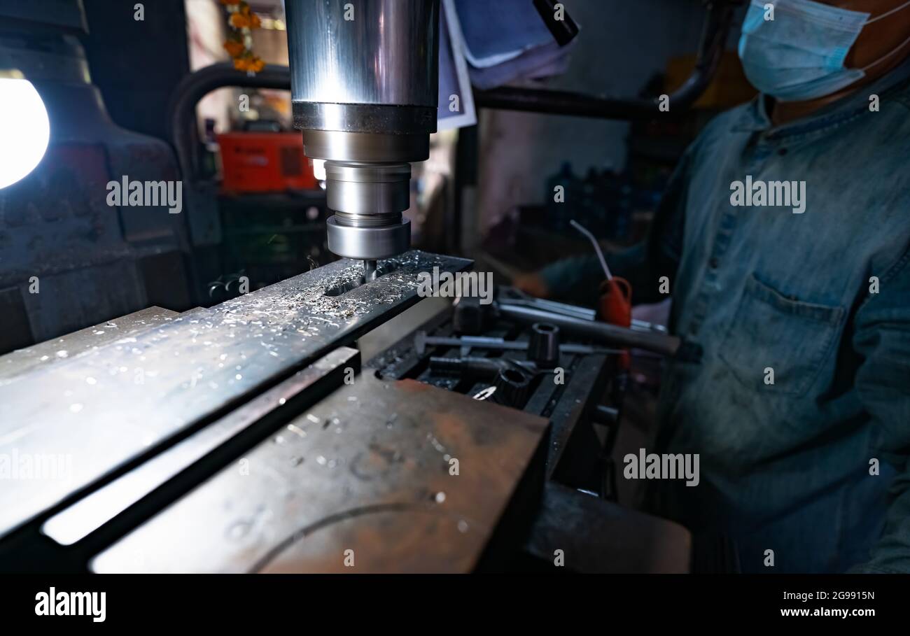 A man wear surgical mask working with milling machine. Tool for cut ...