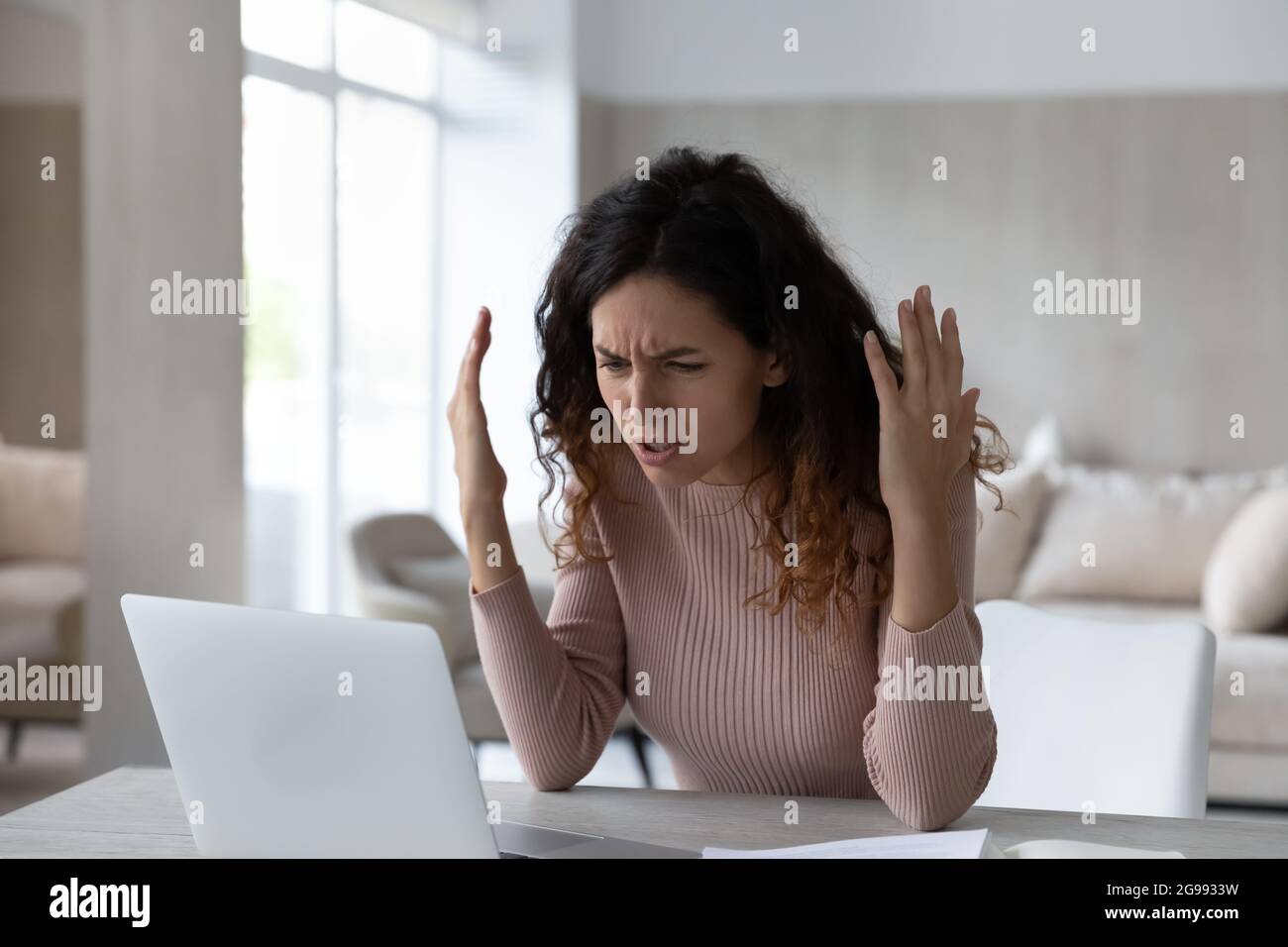 Unhappy Latino woman distressed with computer problem Stock Photo - Alamy
