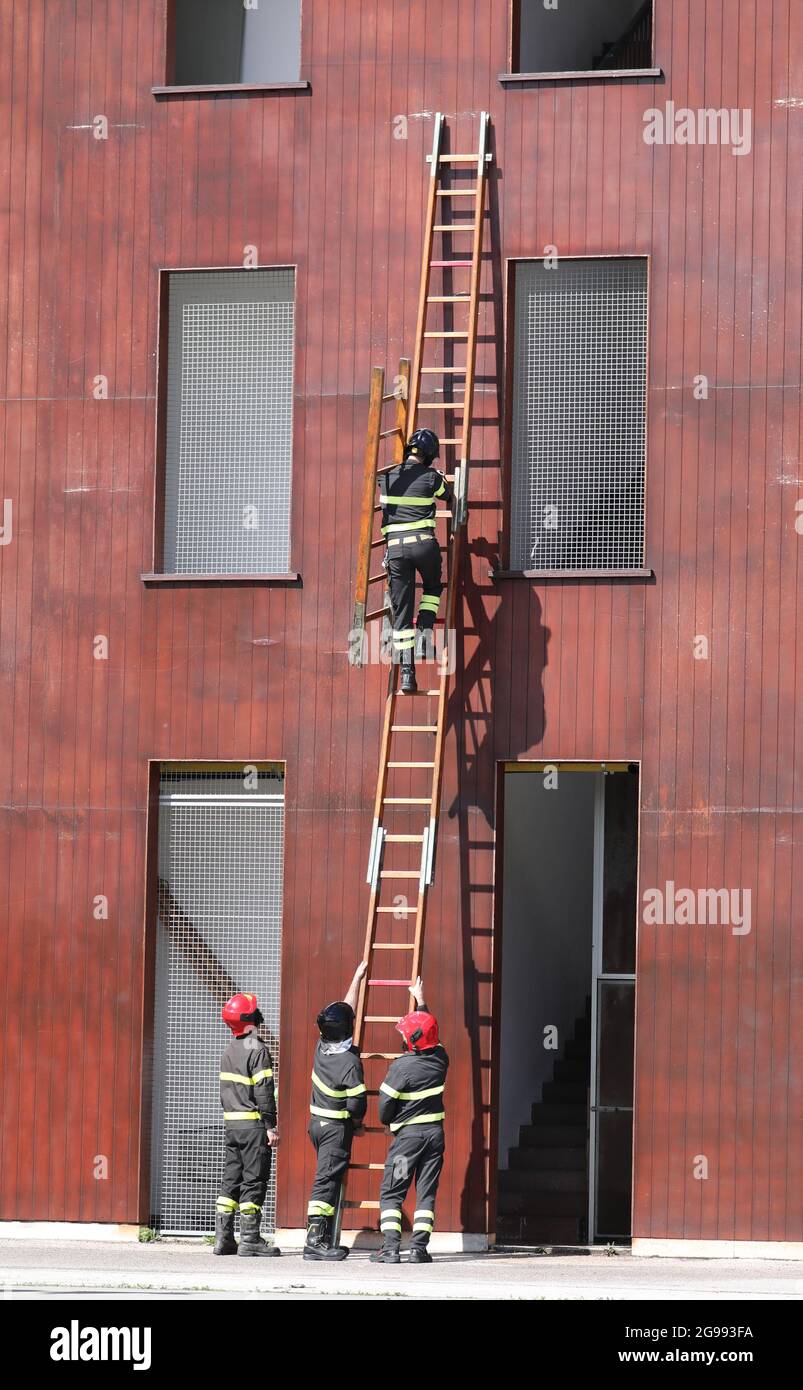 fire brigade team performing an exercise in using the stairs to reach ...