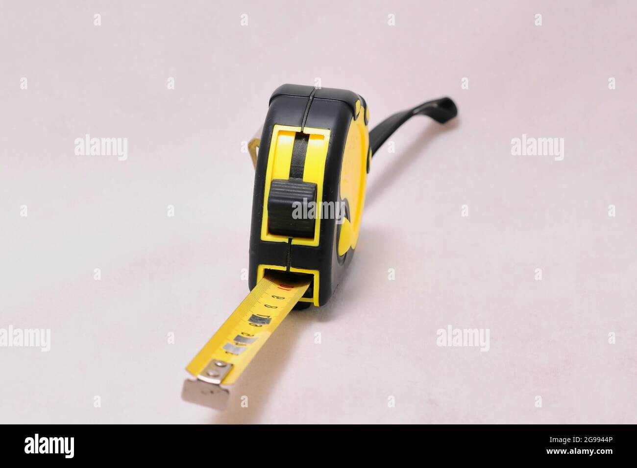 A shot of the yellow measuring tape in the white plain background Stock ...