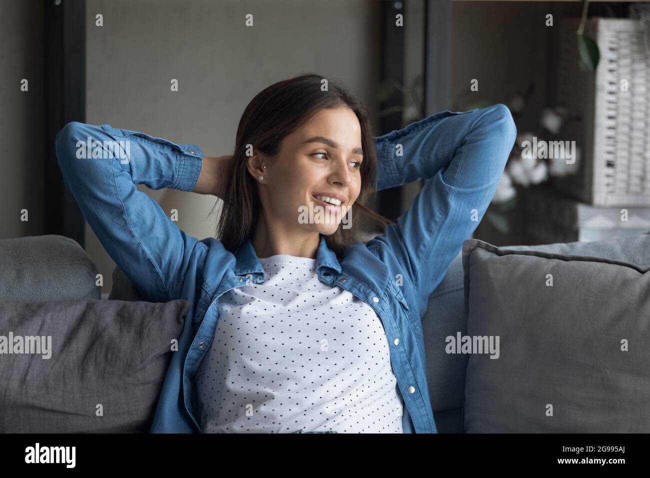Dreamy beautiful woman resting at home seated on sofa Stock Photo - Alamy