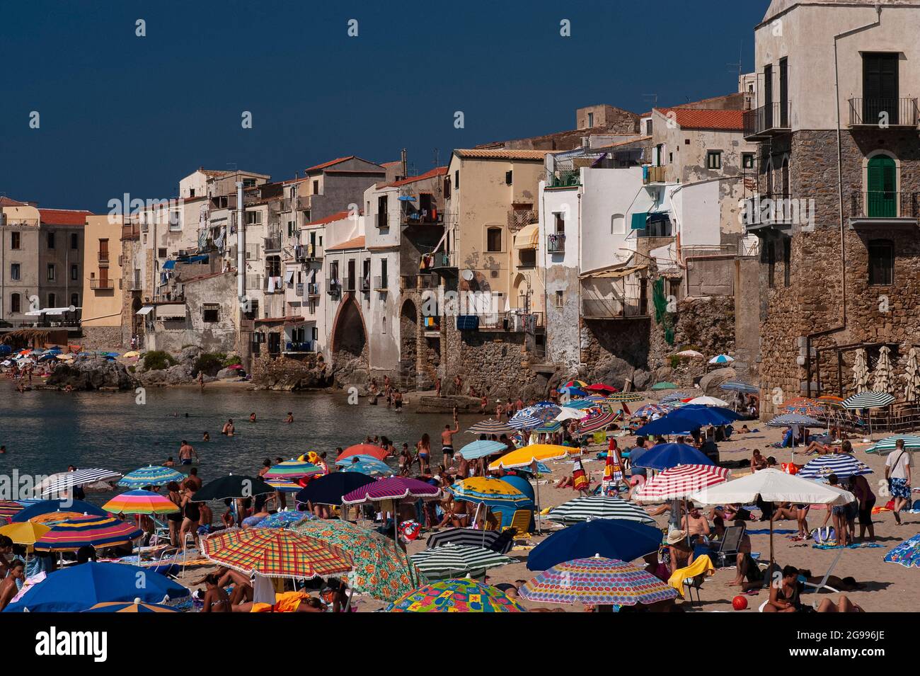 Bronzed bodies and vivid beach umbrellas - sedate stripes mingling with ...