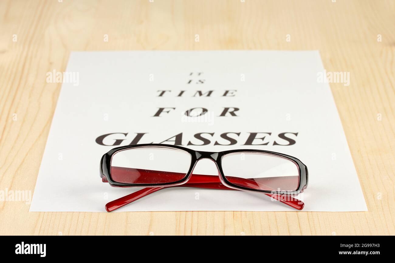 Eyesight test chart with glasses on wooden background close-up Stock ...