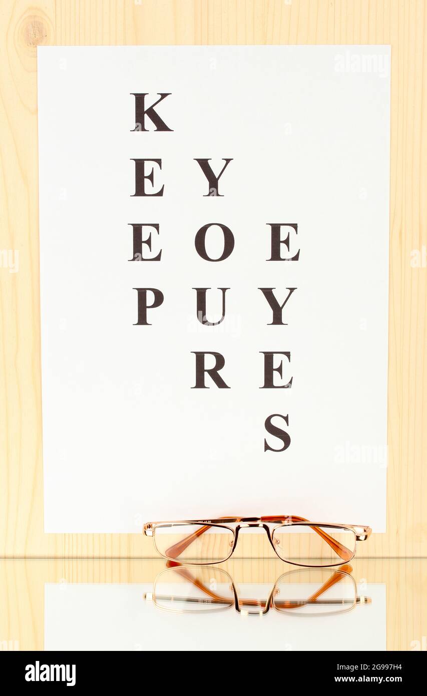 Eyesight test chart with glasses on wooden background close-up Stock ...