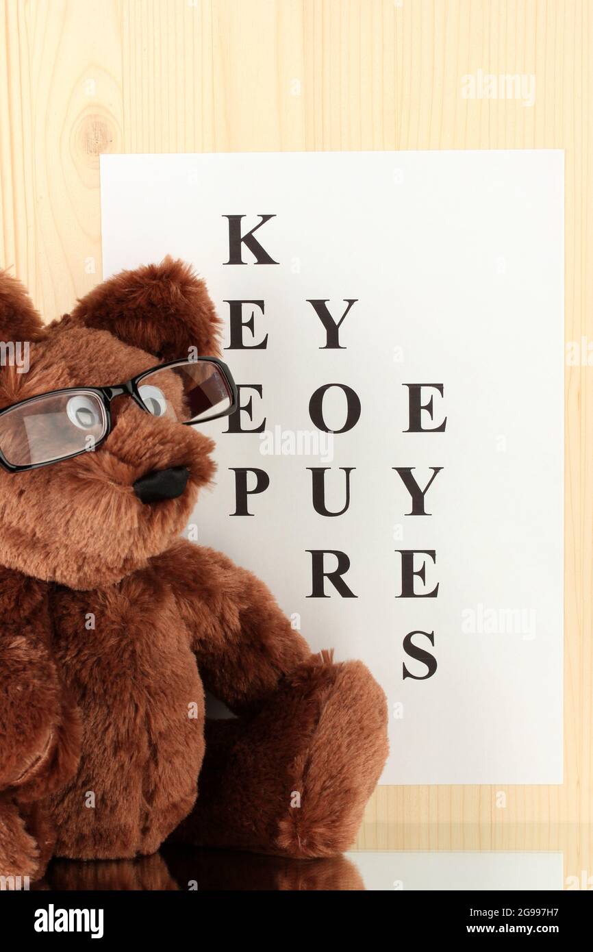 Eyesight test chart with glasses and with toy on wooden background ...