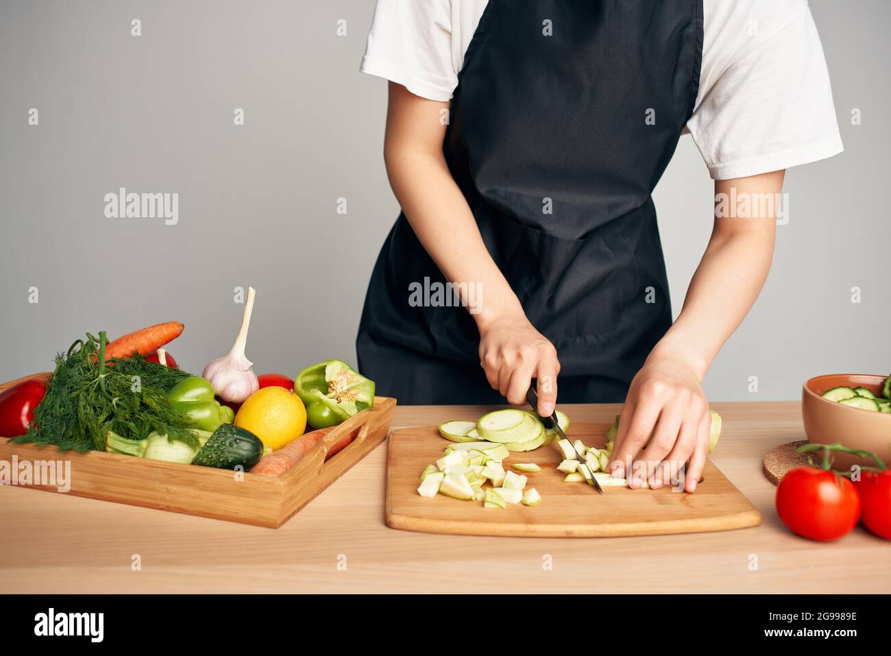 housewife in the kitchen cutting vegetables on a cutting board vitamins ...
