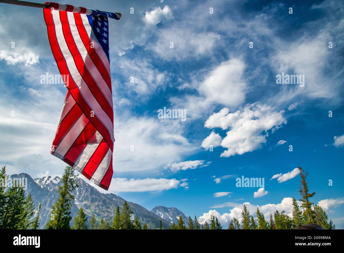 American flag in Yellowstone National Park surrounded by trees and ...