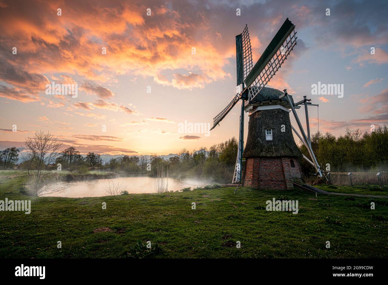 A scenic view of a windmill on a sunset background Stock Photo - Alamy