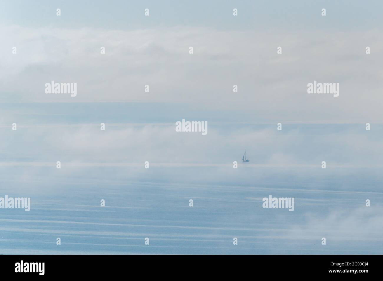 Sailboat sailing in the high seas covered in clouds and fog Stock Photo ...