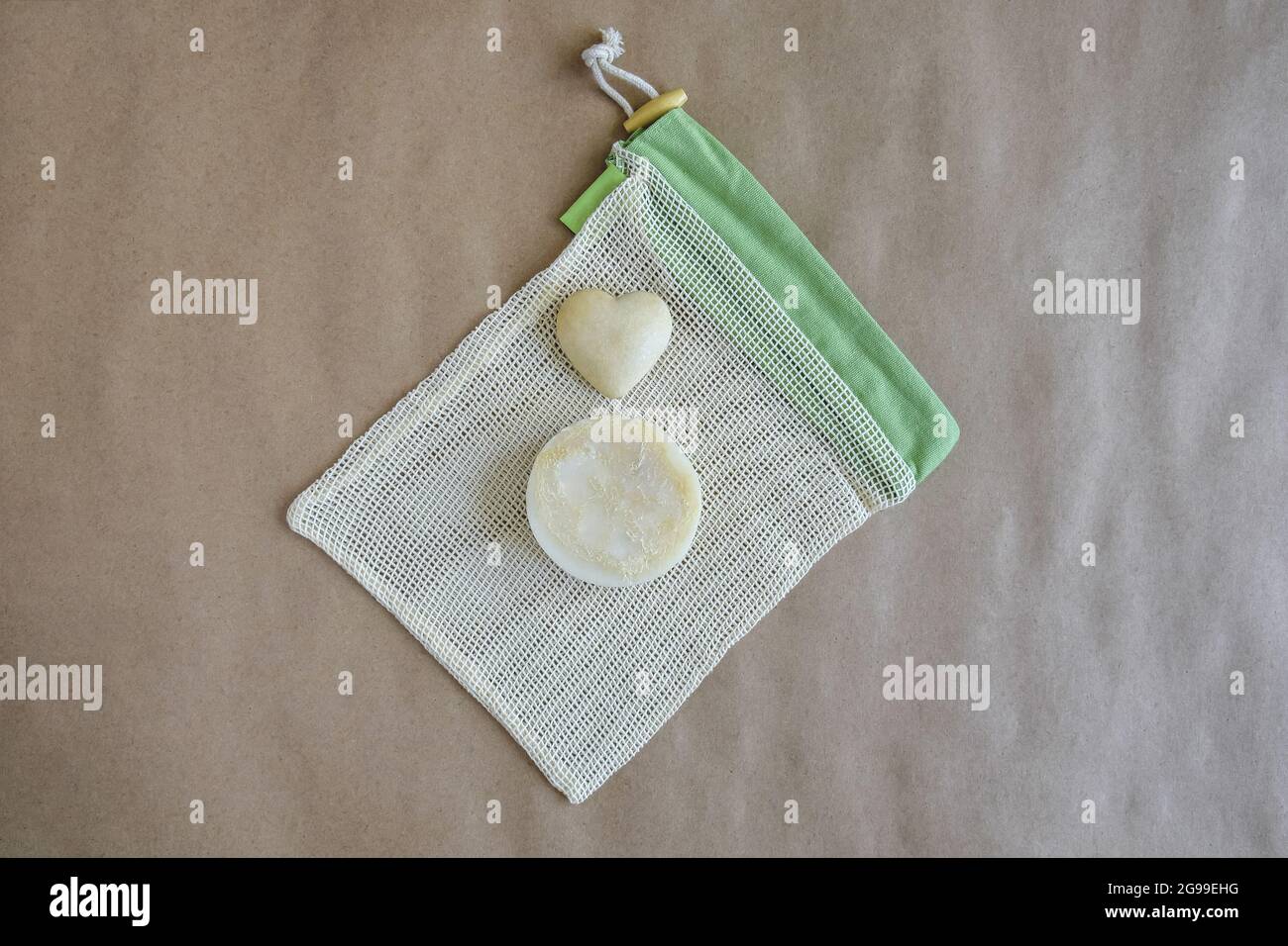 Round natural handmade soap on mesh packaging bag and souvenir stone ...