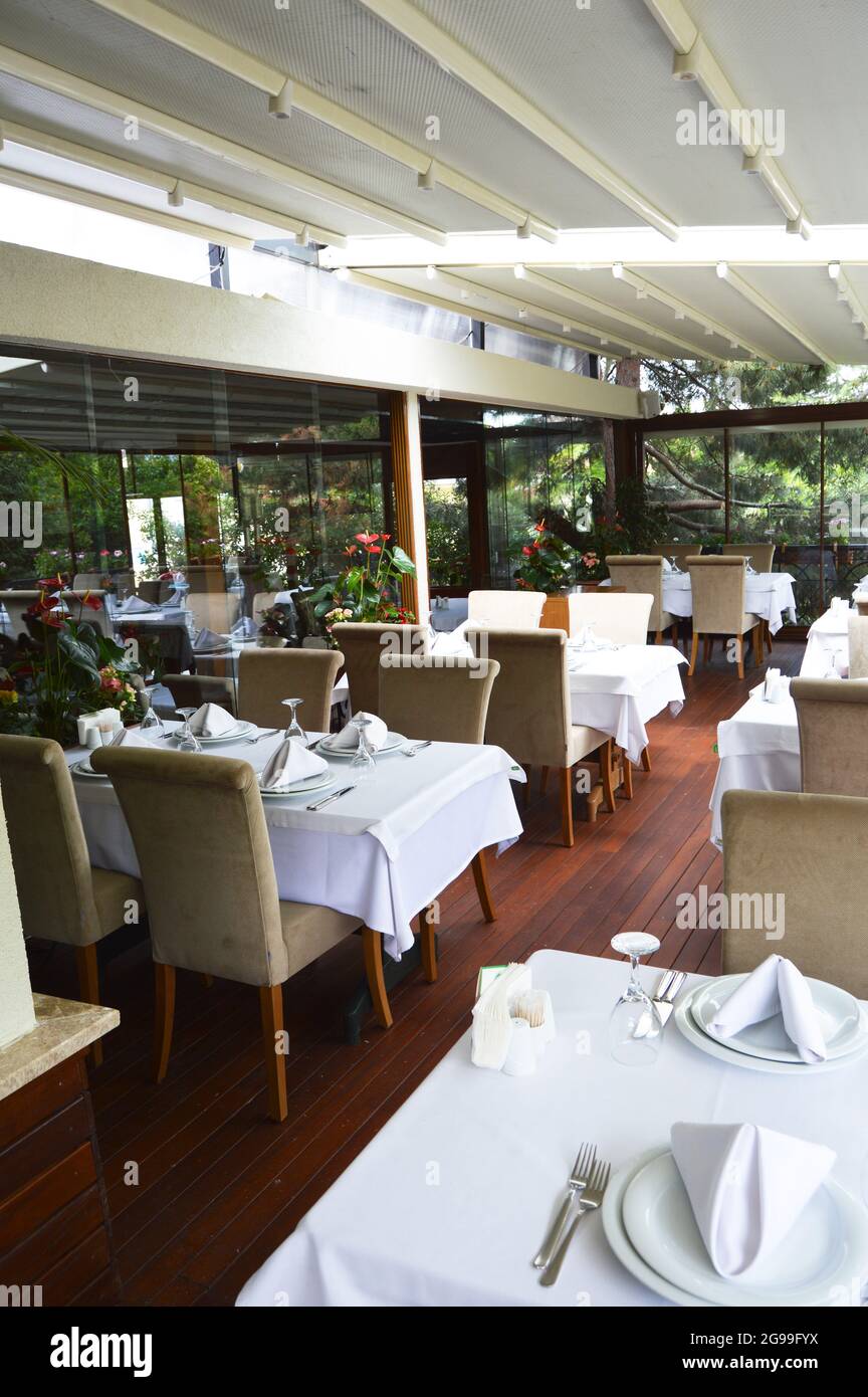 Ornate empty dining tables in a modern restaurant ready to serve, a ...