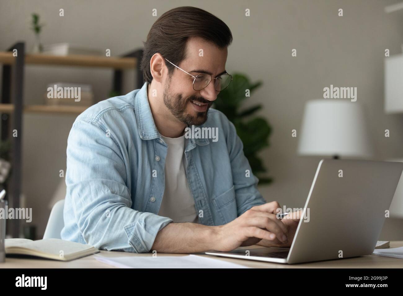 Man sit at desk texting on laptop working from homeoffice Stock Photo ...
