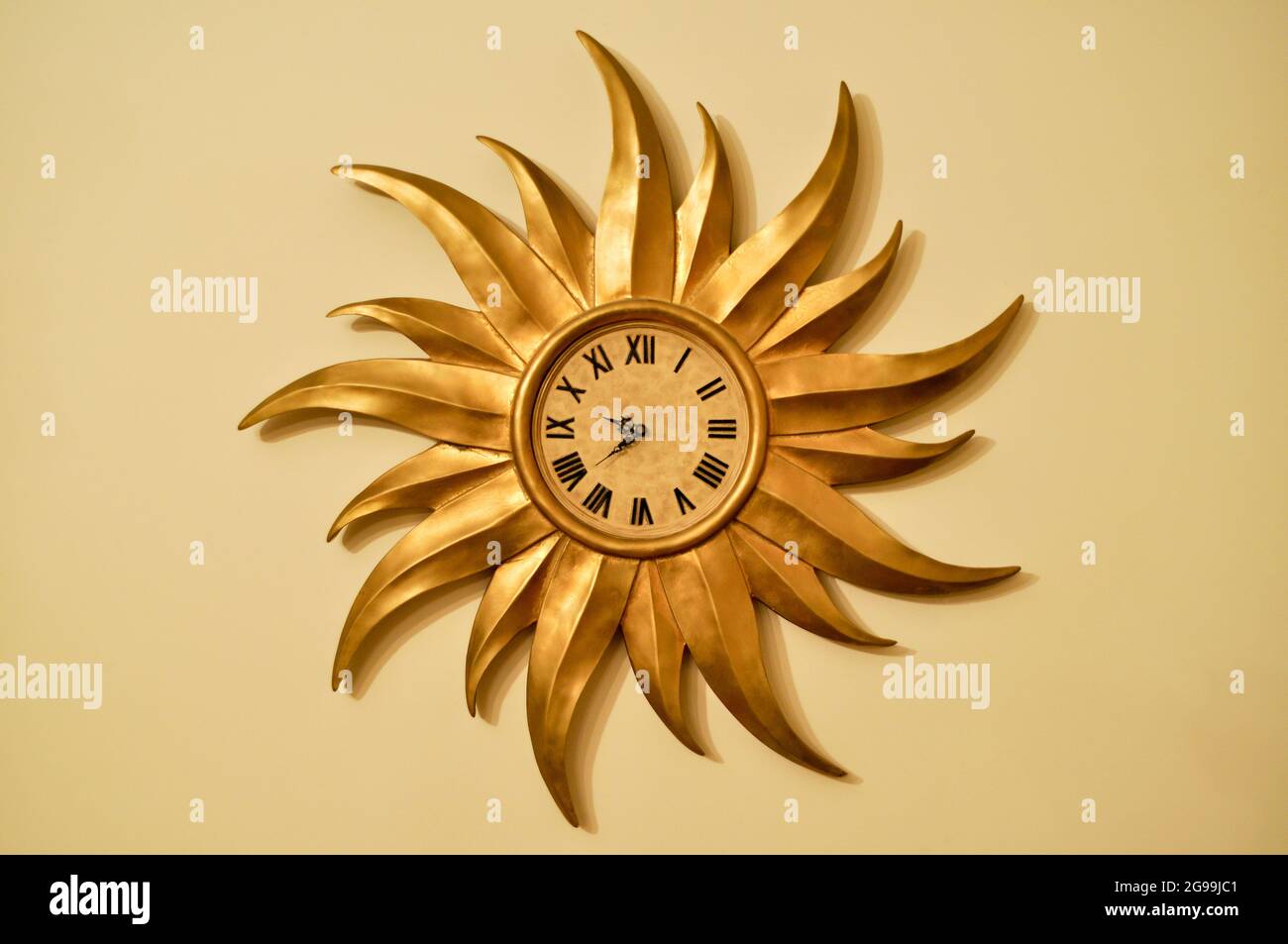 Roman numeral wall clock in a sun wooden frame, isolated on beige ...