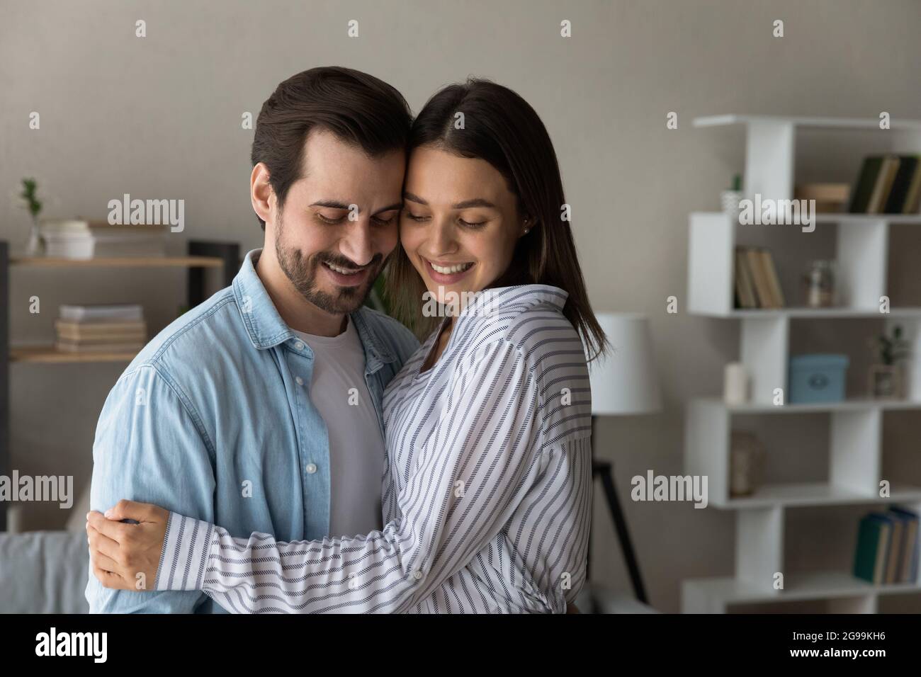 Couple in love cuddling standing inside of modern house Stock Photo - Alamy