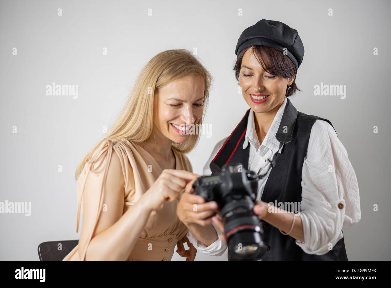 Photographer showing photos to model Stock Photo - Alamy