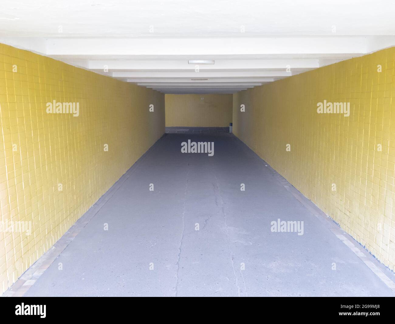 Empty yellow underground pedestrian crossing. Tunnel and daylight at ...