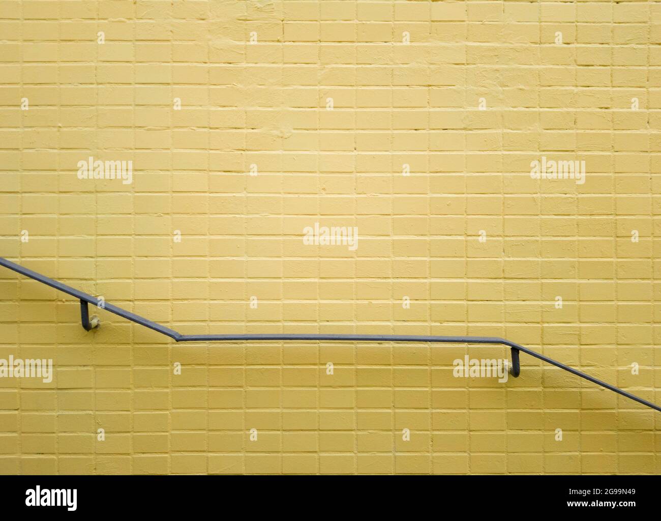 Railings of gray metal near a yellow brick wall. Yellow background ...