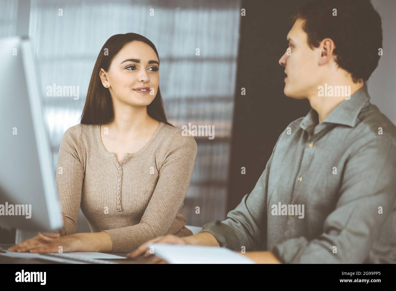 Friendly young businessman and programmer in a green shirt is working ...